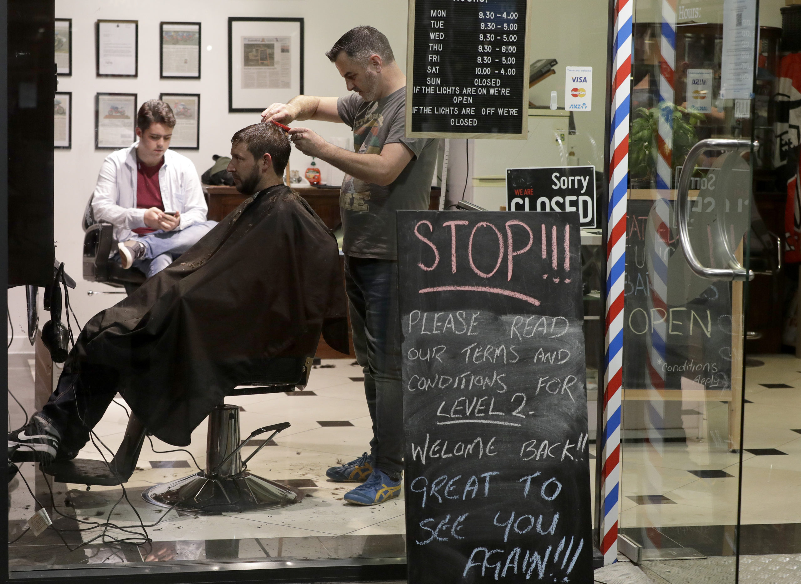 New Zealand barber snips away at midnight as nation reopens | Inquirer News