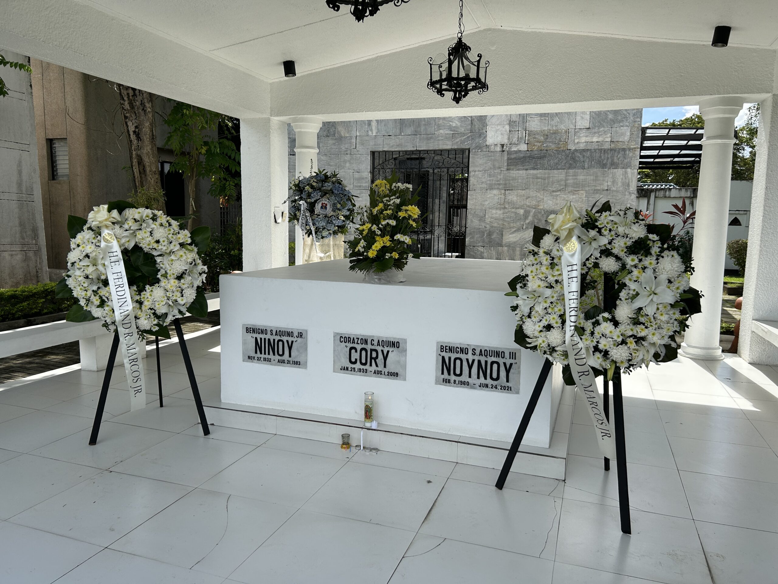 Marcos, Manila gov't offer flowers at Aquinos' graves